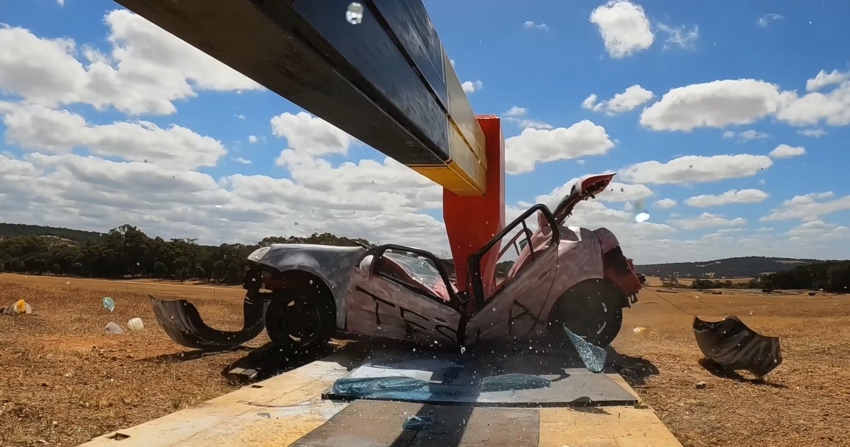 Watch This Giant Axe Split Not-A-Tesla In Half In A Very Aussie Experiment