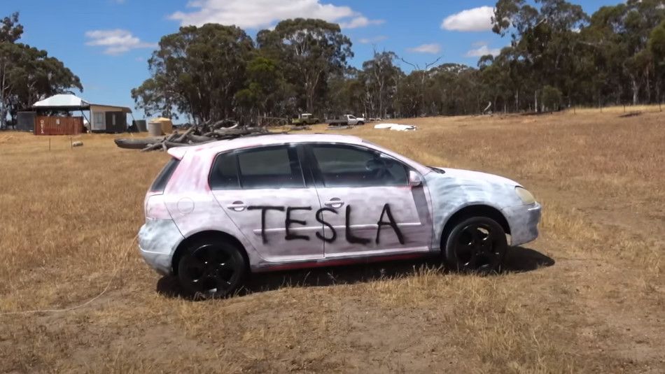 Watch This Giant Axe Split Not-A-Tesla In Half In A Very Aussie Experiment